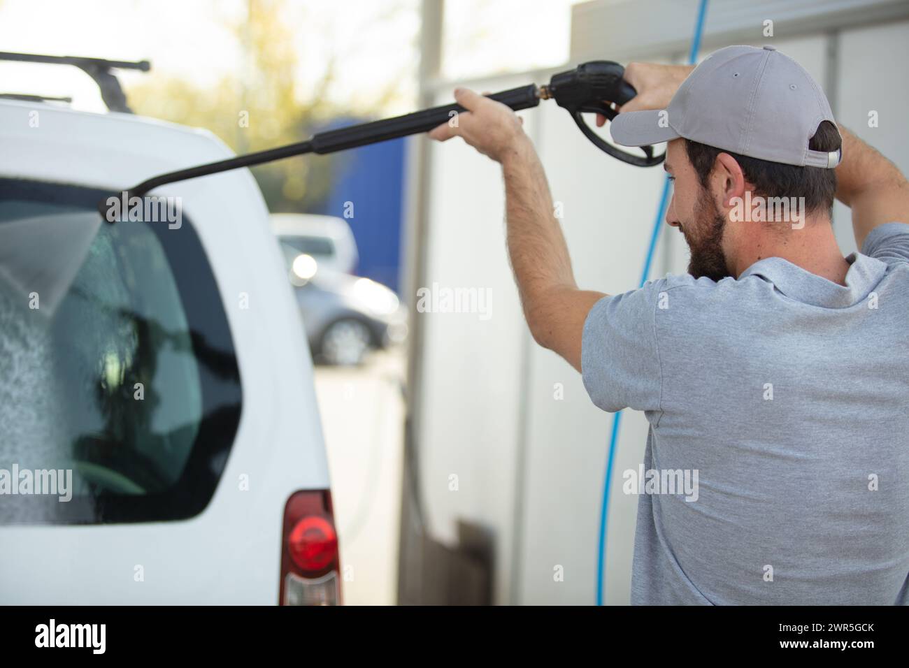 man cleaning van with a pressure washer Stock Photo - Alamy
