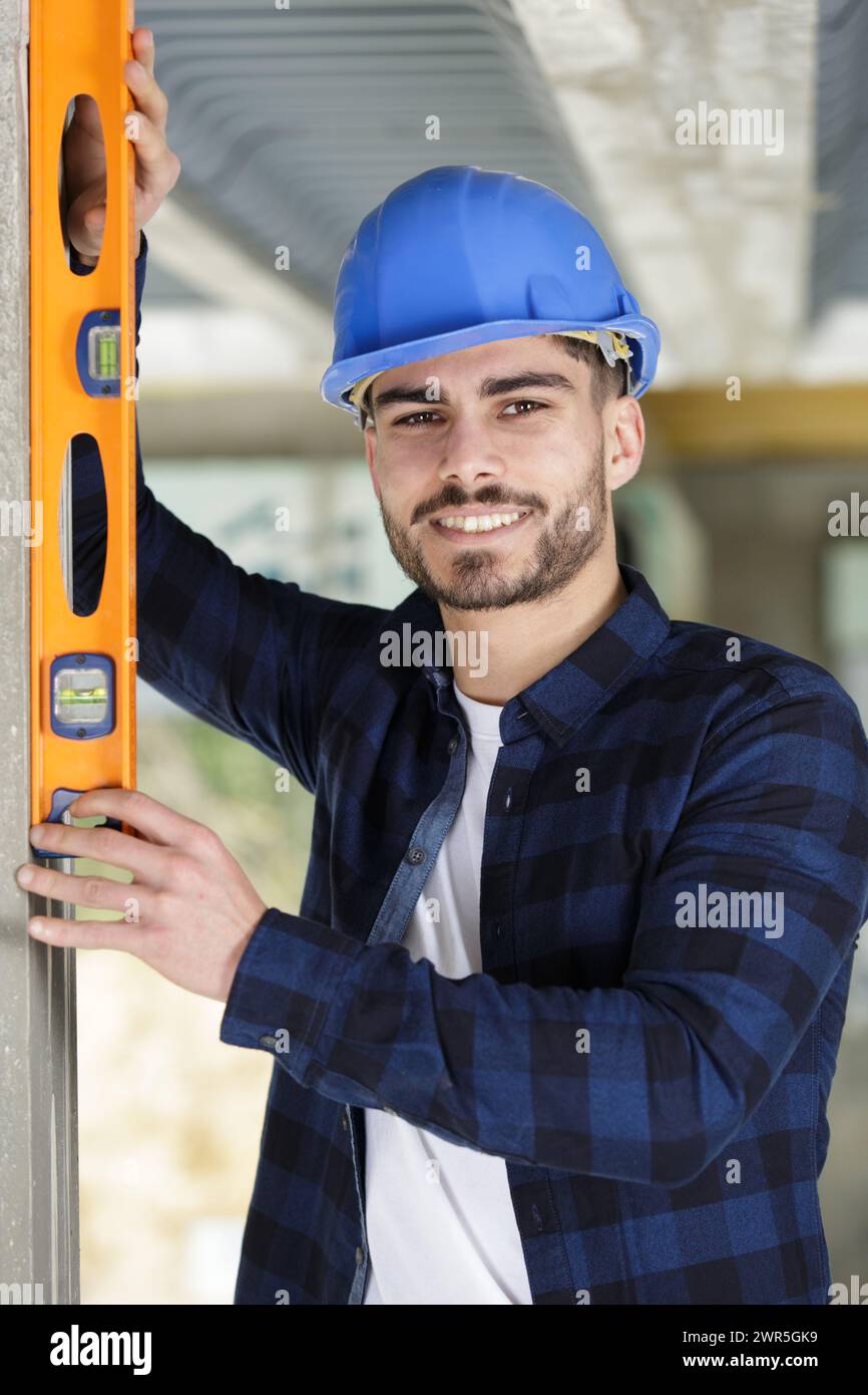 worker on a construction site measuring wall with spirit level Stock ...