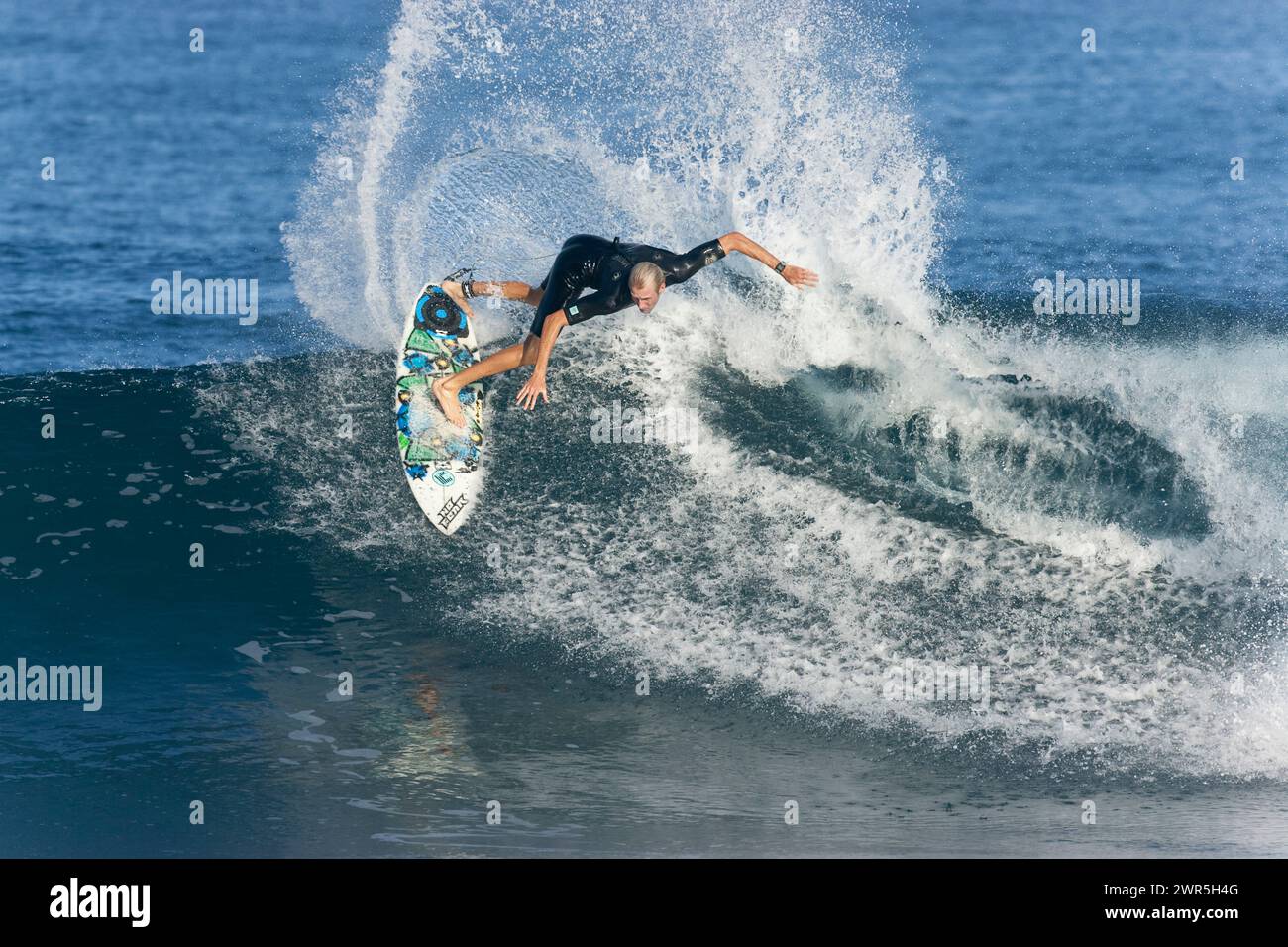 A young man surfing at Rocky Point, on the north shore of Oahu, Hawaii ...