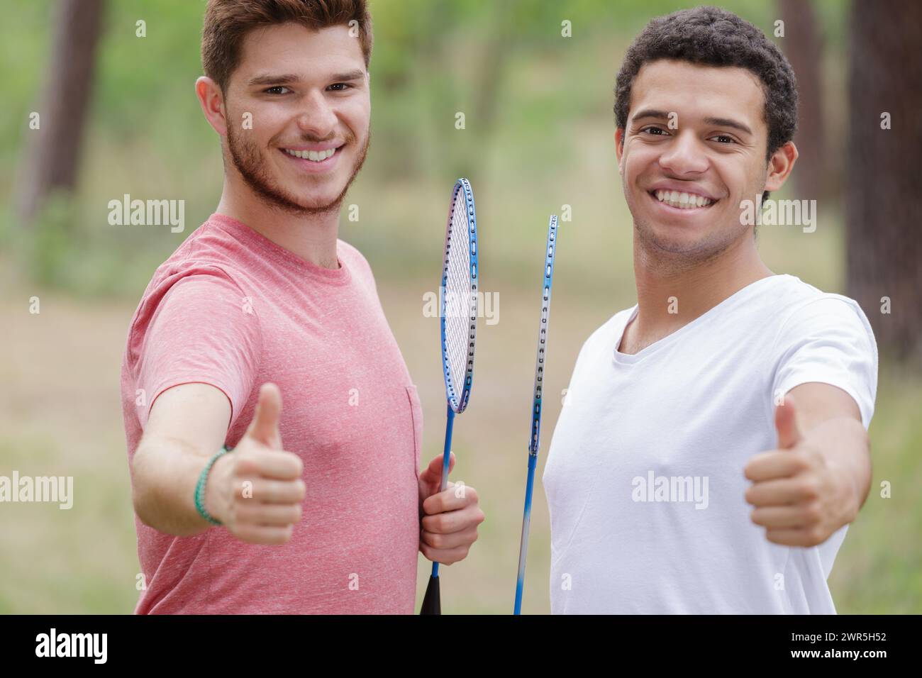 two male badminton players holding thumbs up Stock Photo - Alamy
