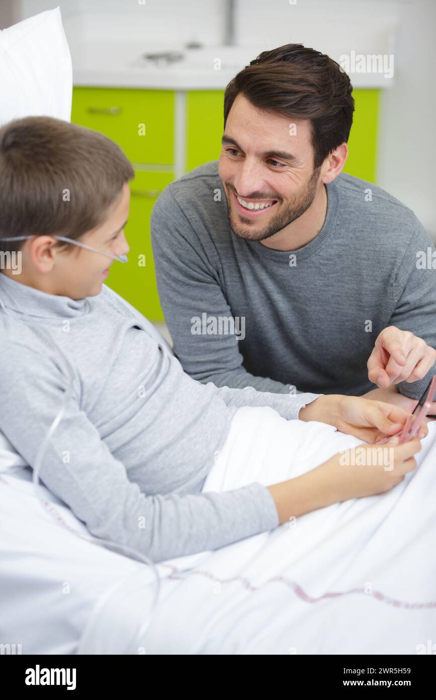 boy in bed at the hospital with his father Stock Photo - Alamy