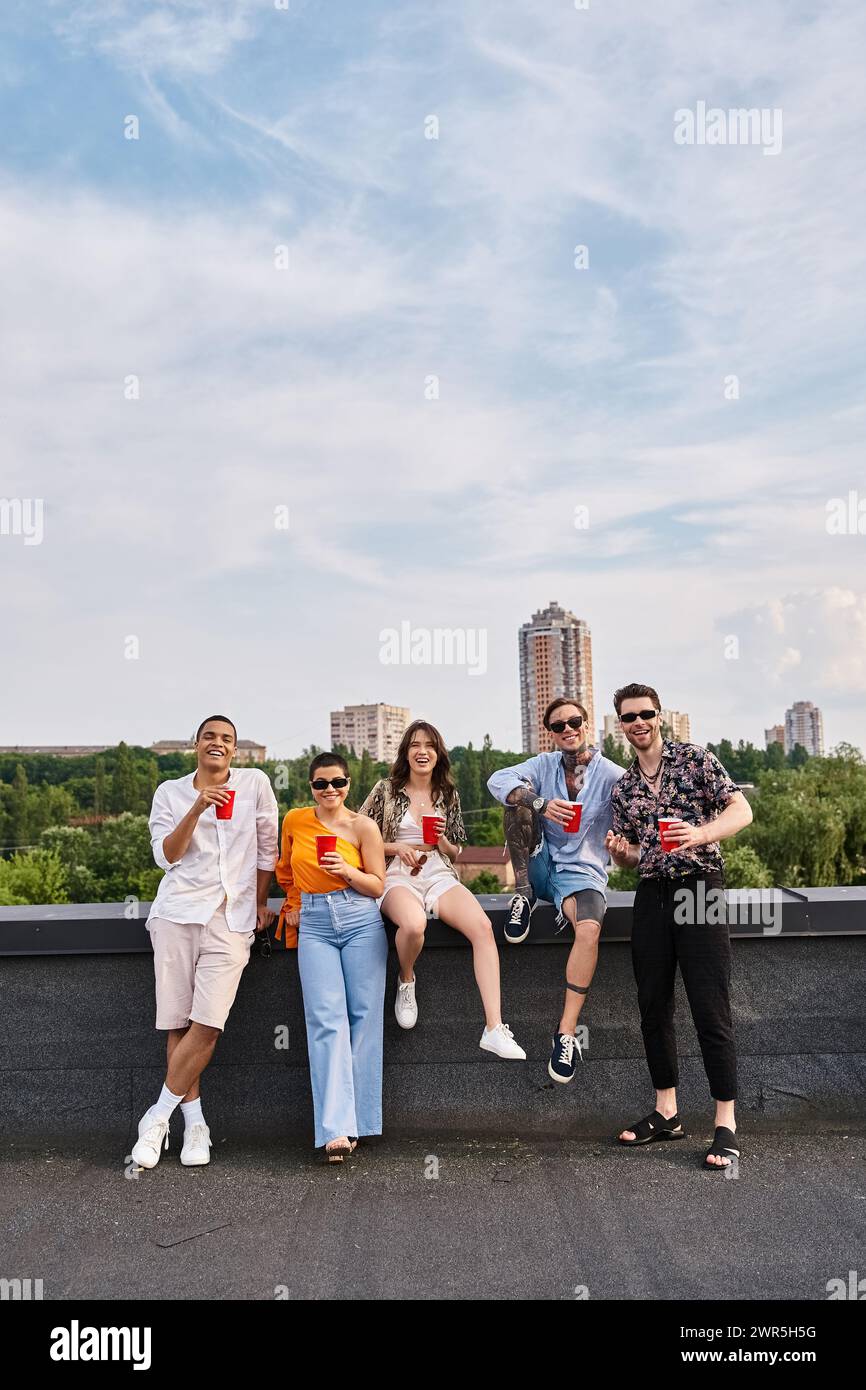 group of cheerful multiracial friends posing with red cups with drinks ...