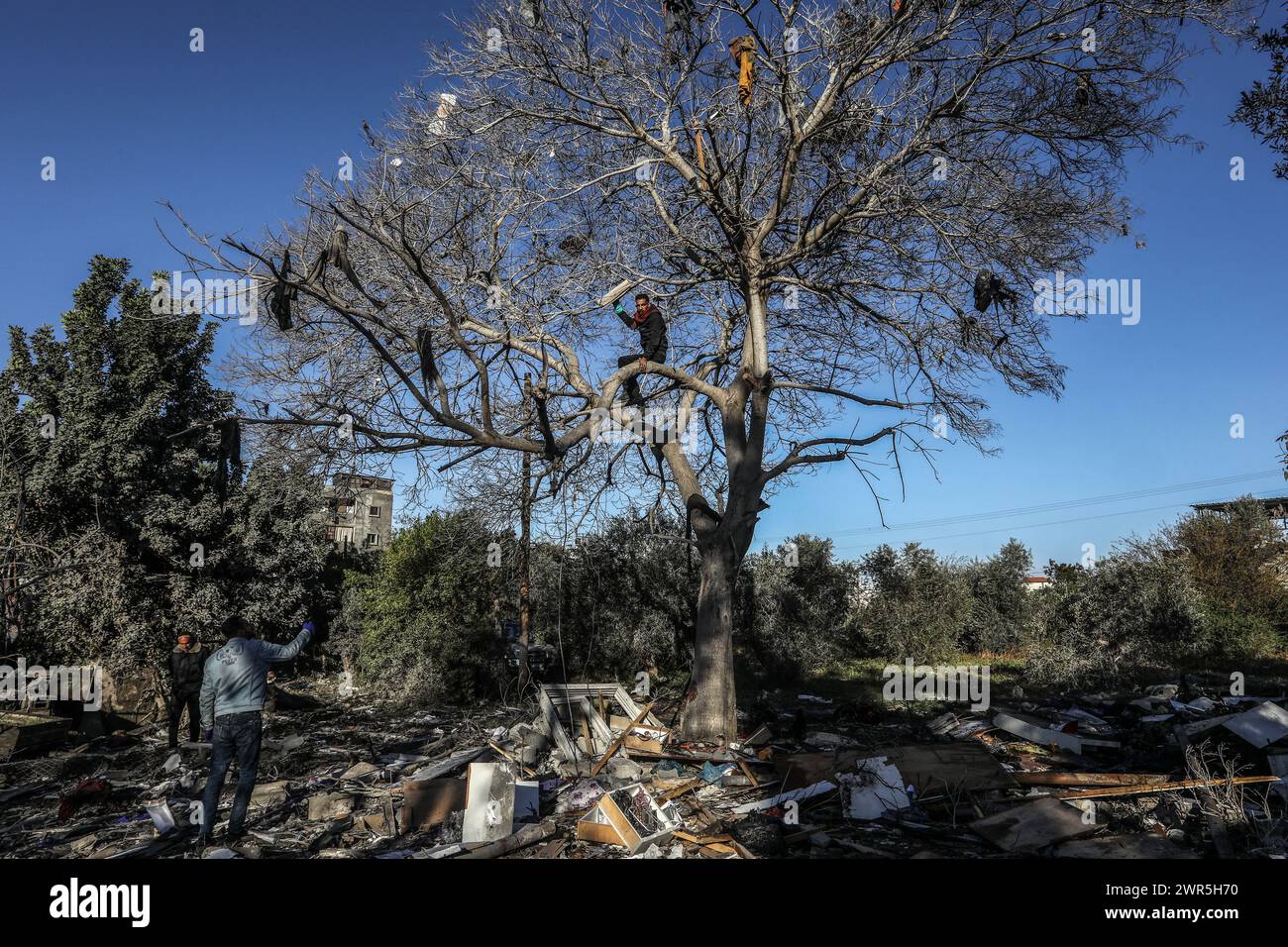 11 March 2024, Palestinian Territories, Rafah: A Palestinian man climbs ...