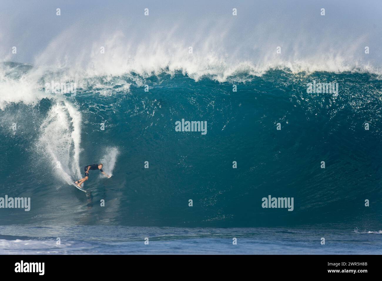 A young man surfing a big wave at Pipeline on the north shore of Oahu ...