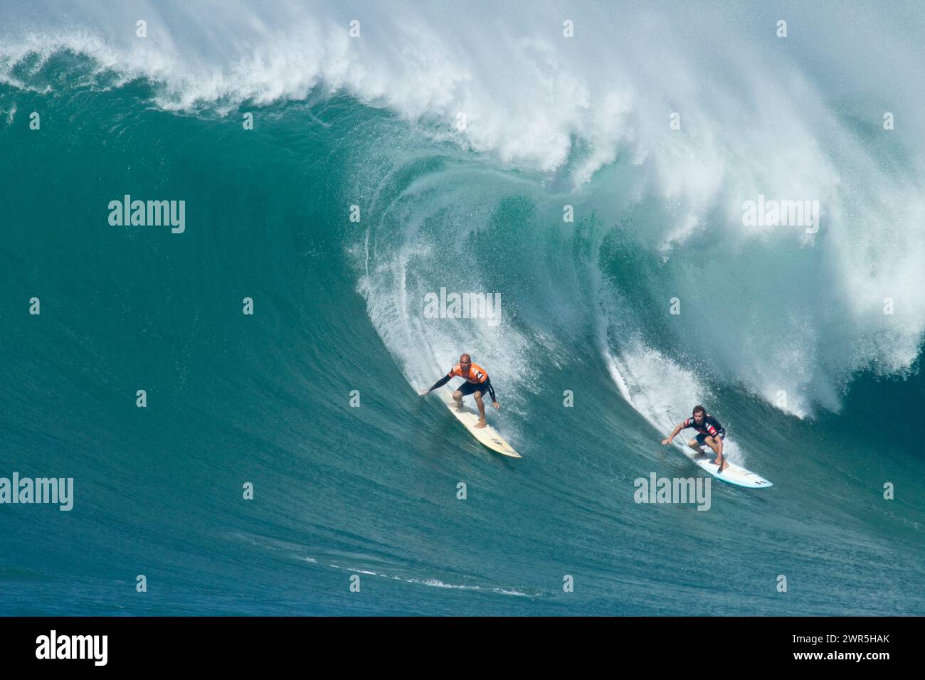 Kelly Slater and Grant Baker surfing a huge wave at the Eddie Aikau big ...