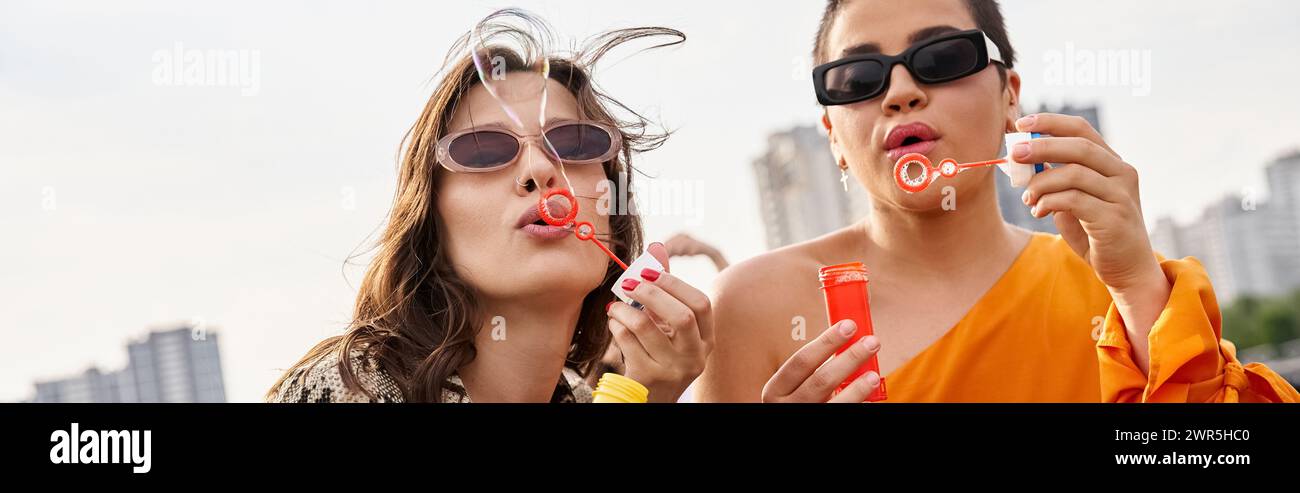 Beautiful Jolly Women In Vibrant Outfits With Sunglasses Blowing Soap