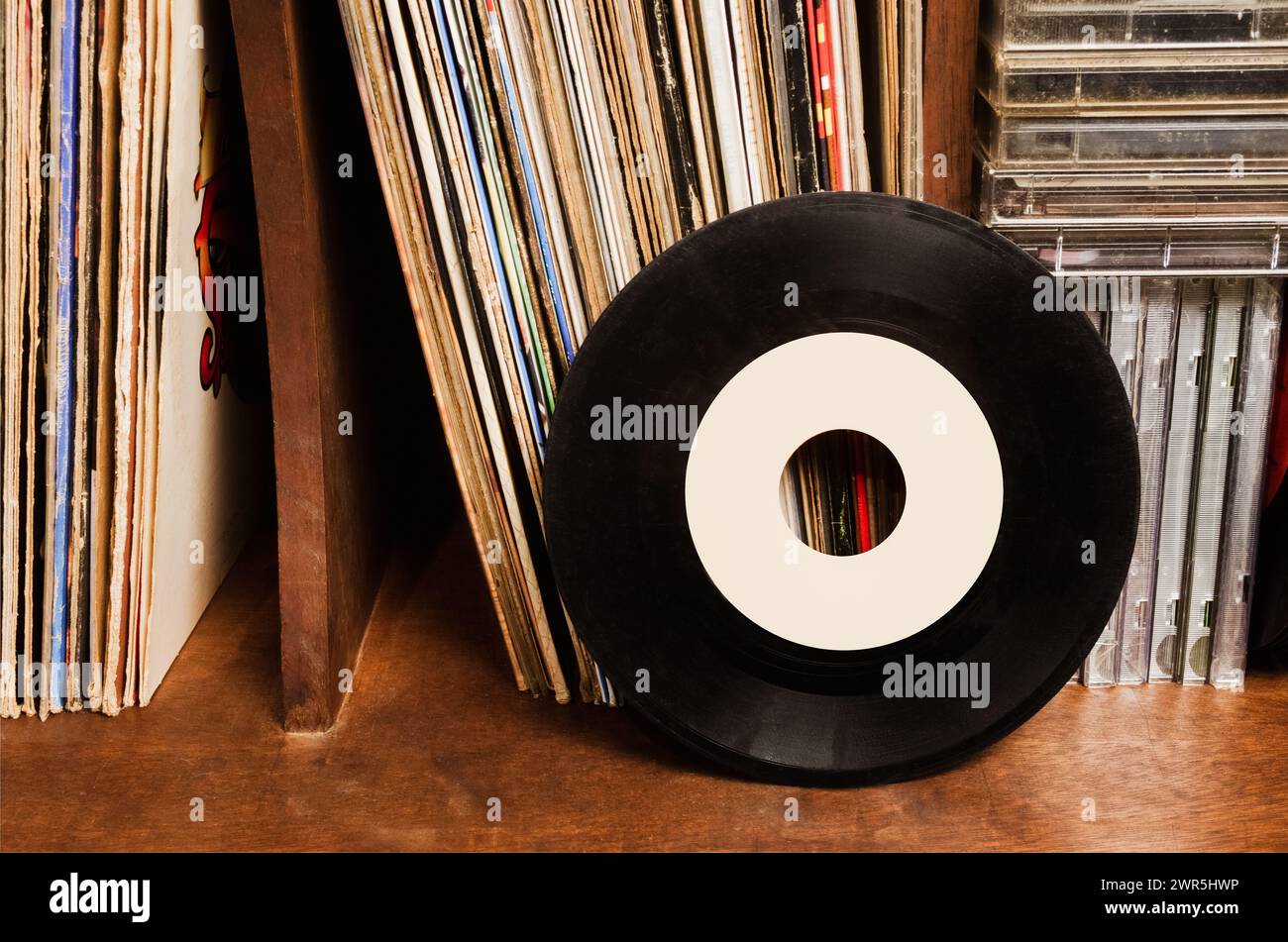 Vinyl records stacked with cassettes on furniture Stock Photo - Alamy