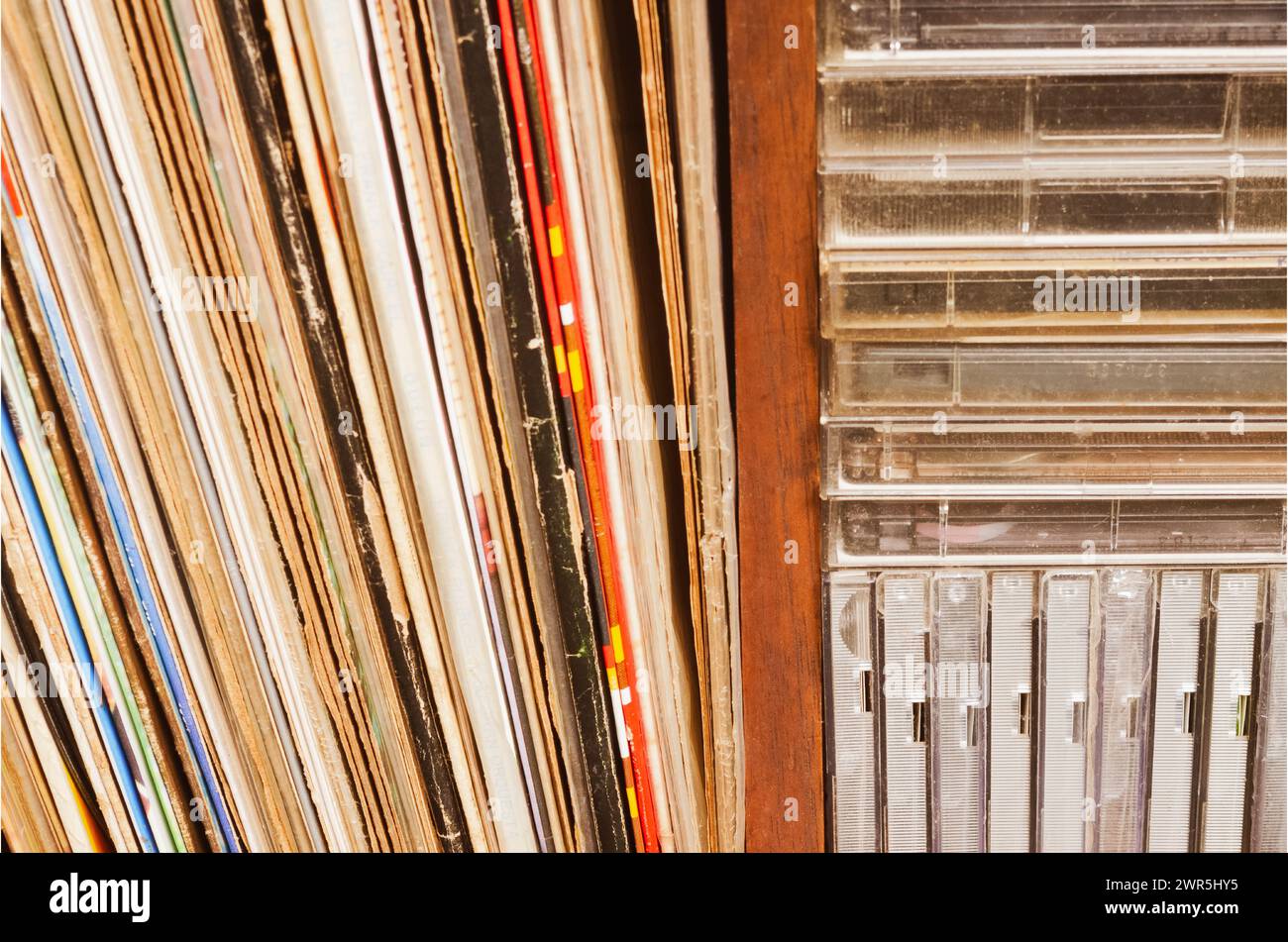Vinyl disc stacked with cassettes on furniture Stock Photo - Alamy