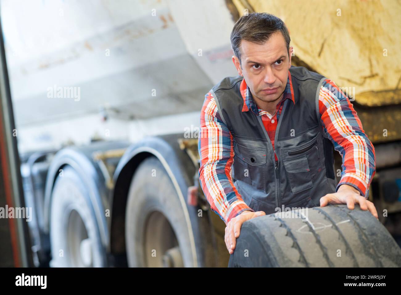 tire service worker carrying car tyre Stock Photo - Alamy
