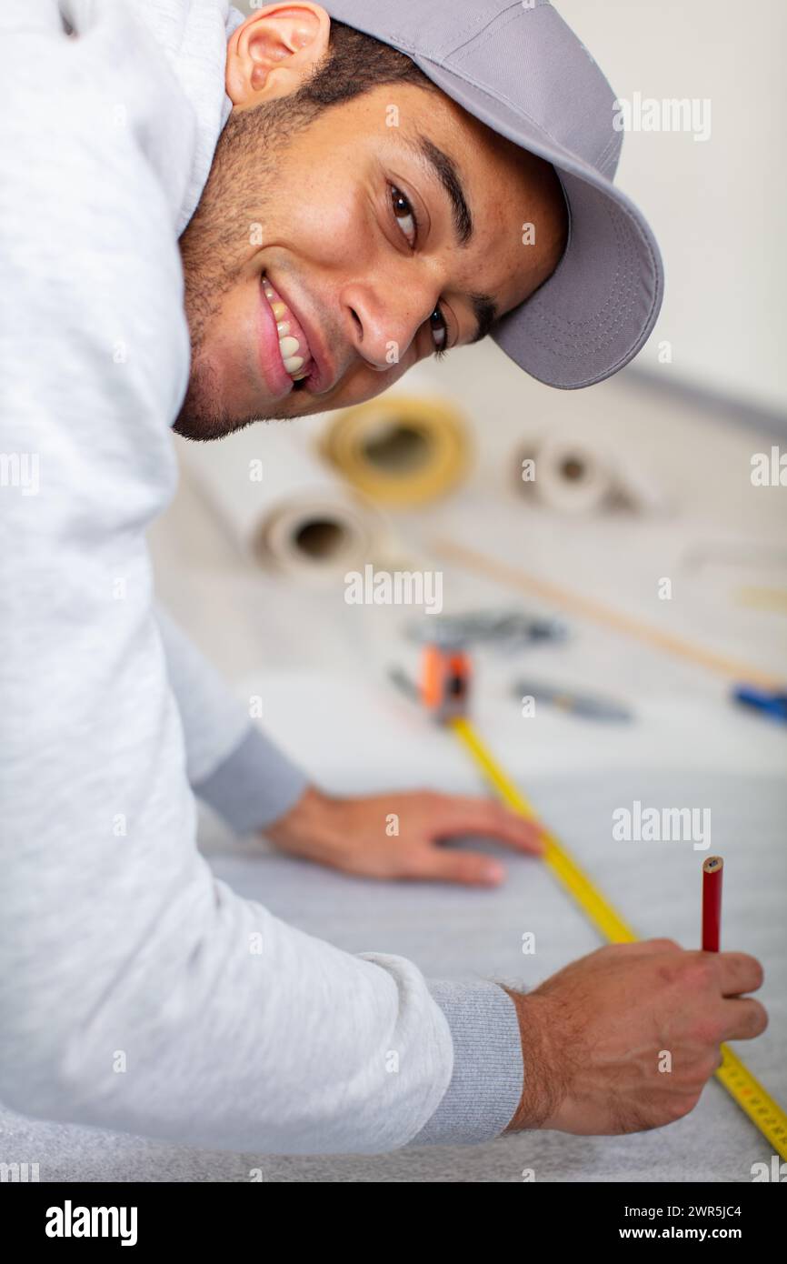builder measuring floor using tape measure and pencil Stock Photo - Alamy