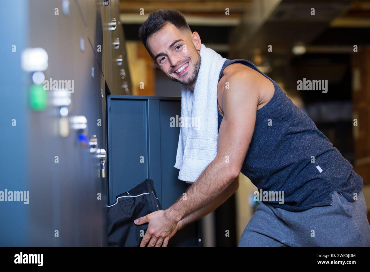 smiling man opening locker in the gym Stock Photo - Alamy