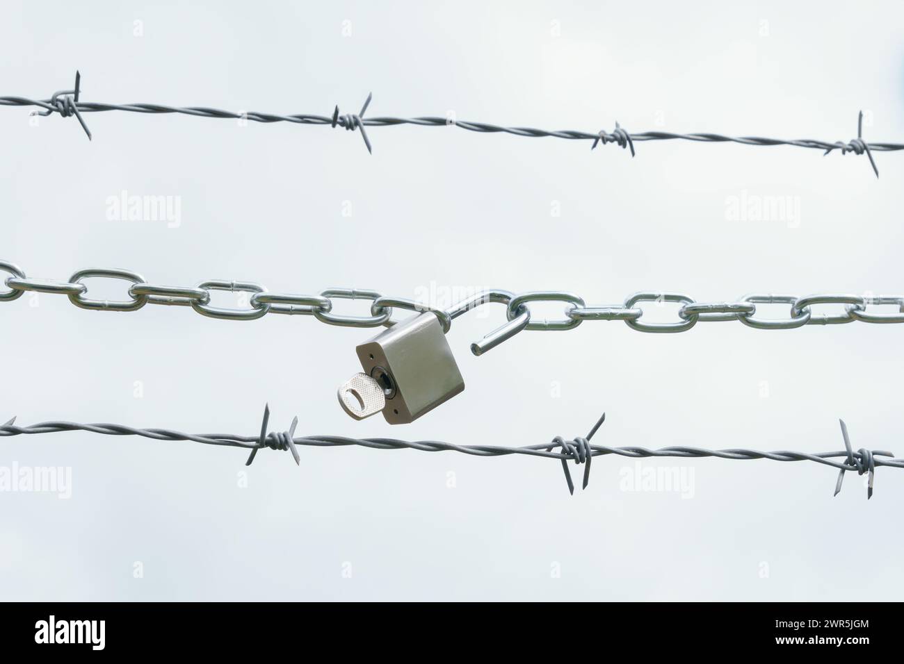 Padlock on barbed wire hi-res stock photography and images - Alamy