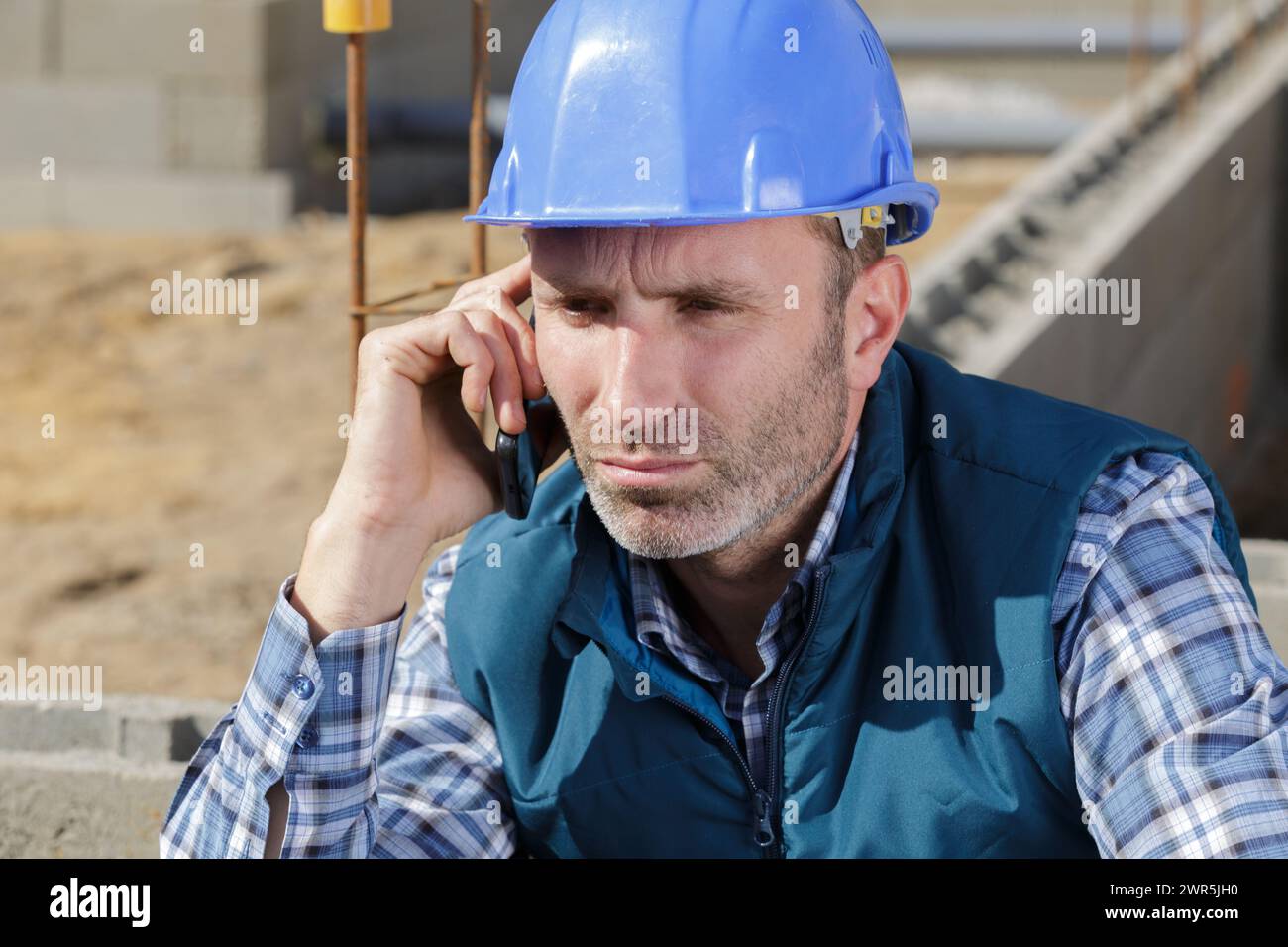 man builder in an helmet talking on the phone Stock Photo - Alamy
