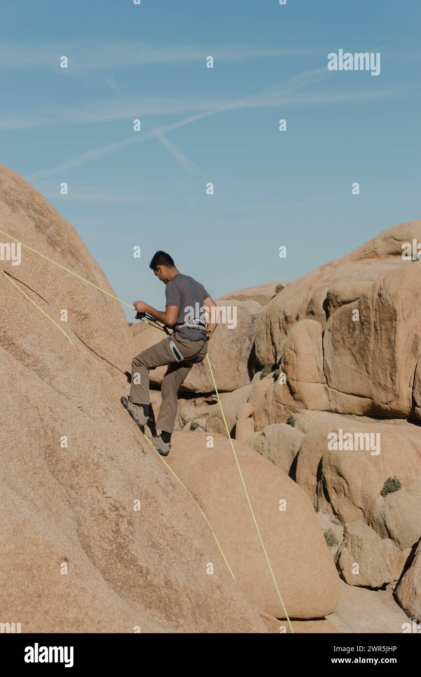Man repelling down rock face at Joshua Tree National Park Stock Photo ...
