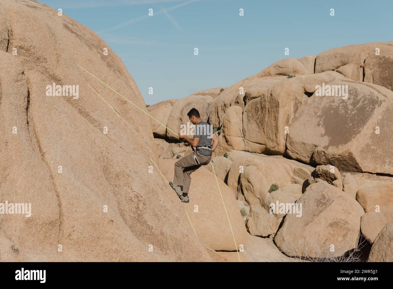 Man repelling down rock at Joshua Tree National Park Stock Photo - Alamy
