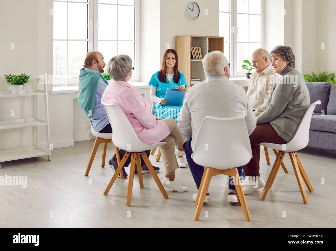 Group of elderly people in retirement home or senior care clinic having ...