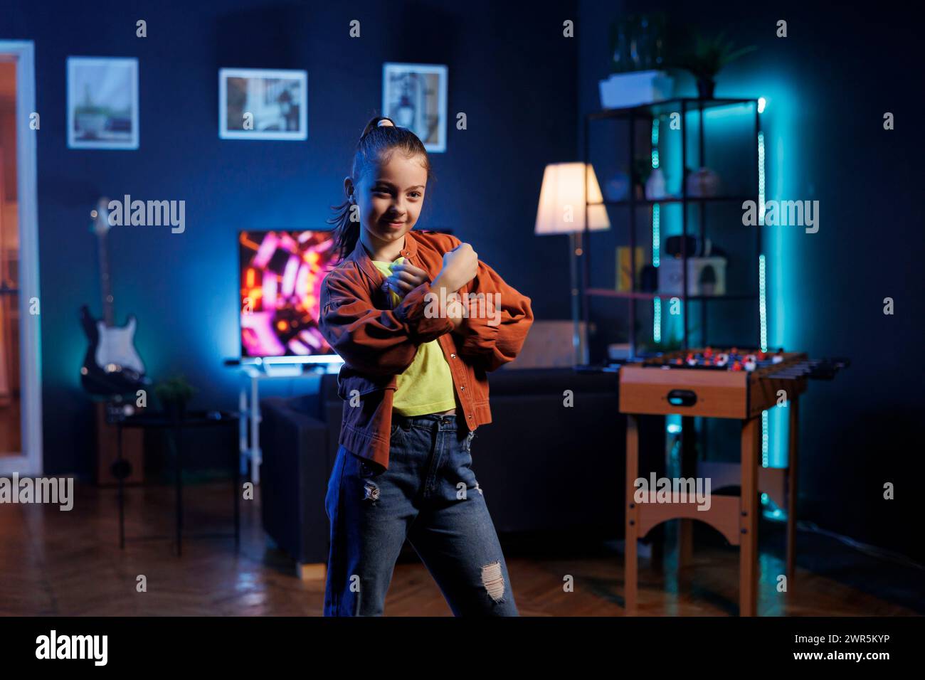 Cute girl performing trending dance routine in living room, surrounded ...