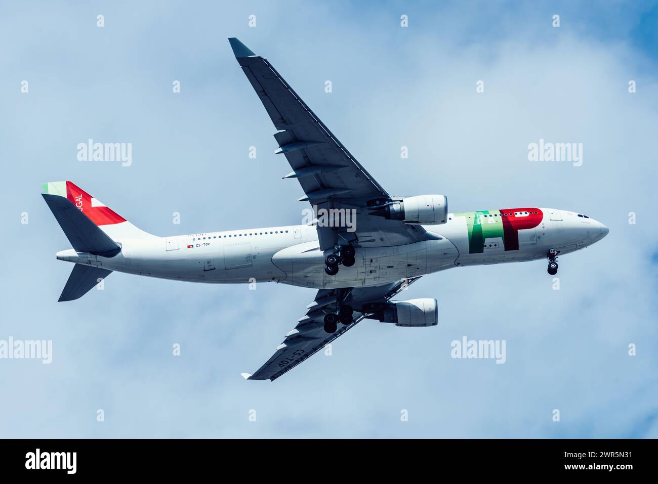 A Portuguese Tap airplane is captured descending with its landing gear ...