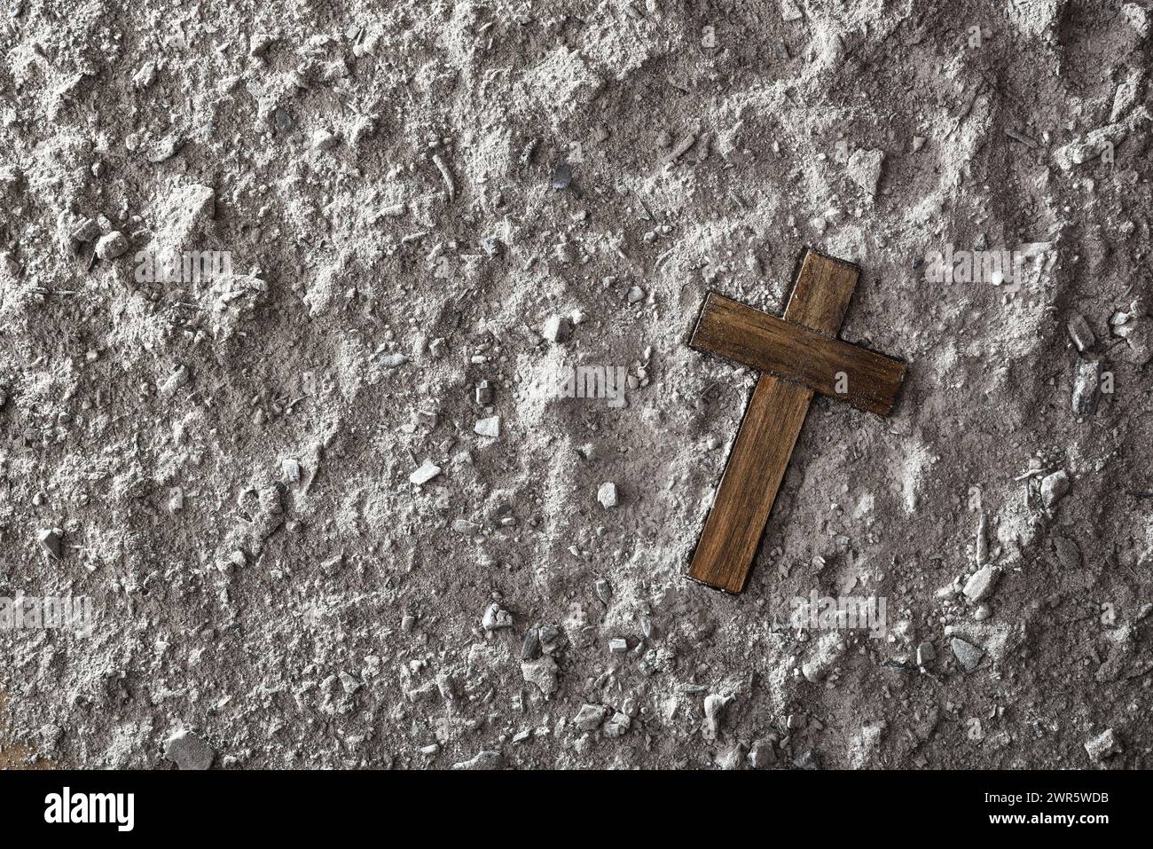Religious background with wooden christian cross on ashes. Top view ...