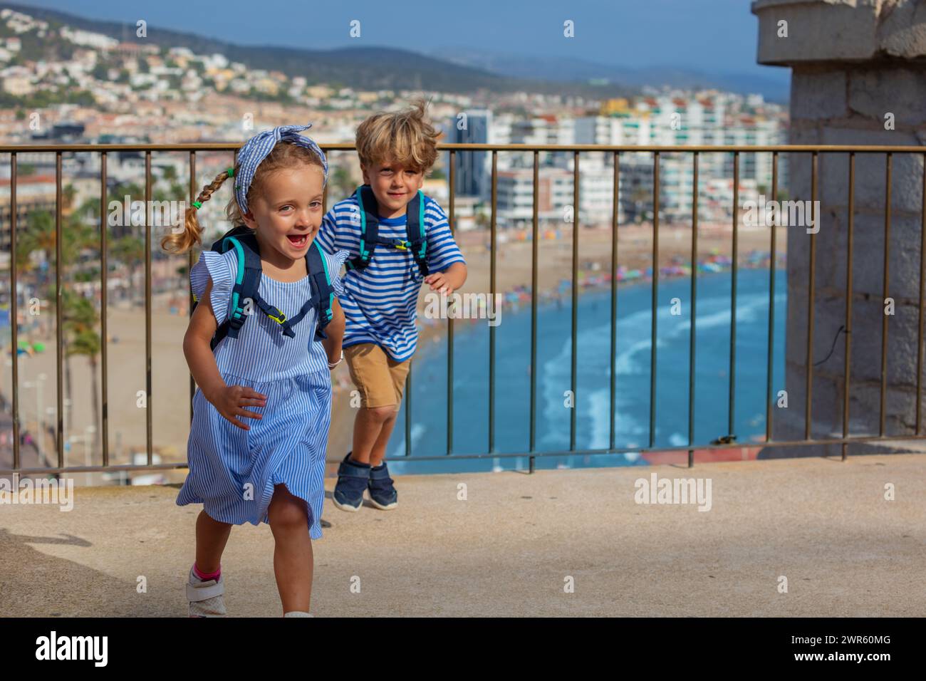 Two cute tourists, boy, girl visiting Spain love coastline view, jump ...