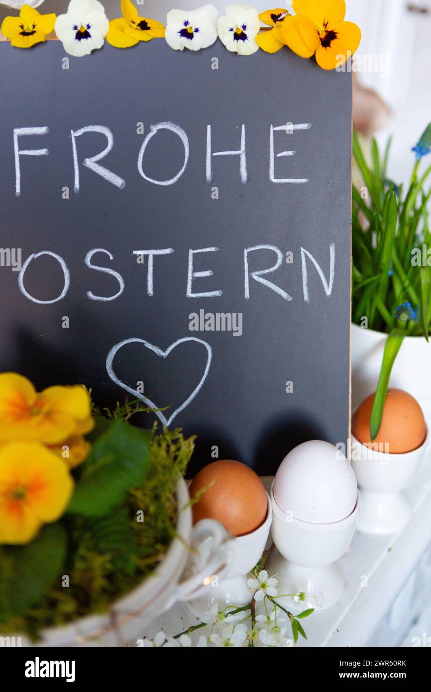 9 March 2024: Happy Easter, greeting on a board surrounded by Easter ...