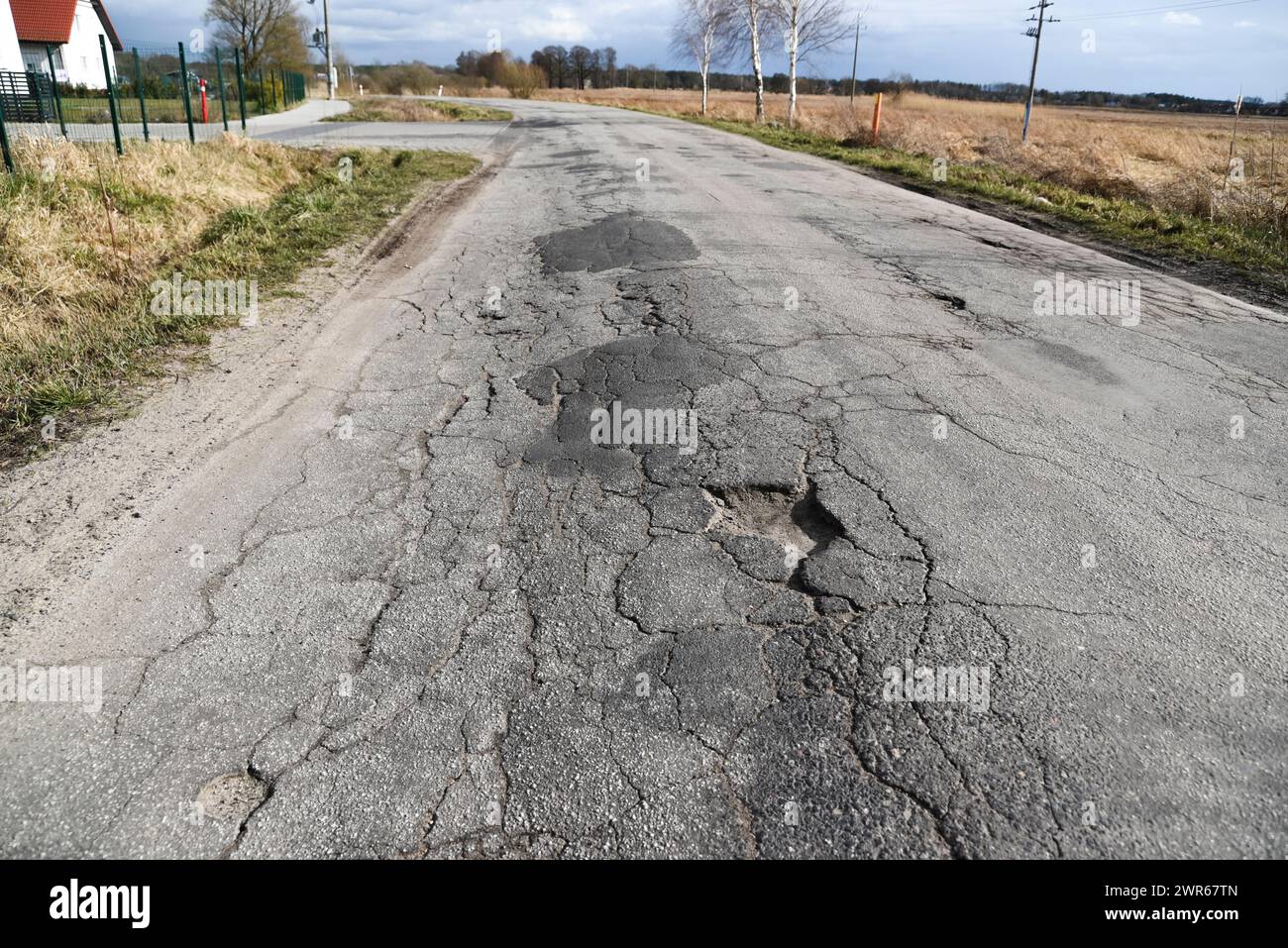 Potholes in the road, a dilapidated asphalt road with rainwater in the ...