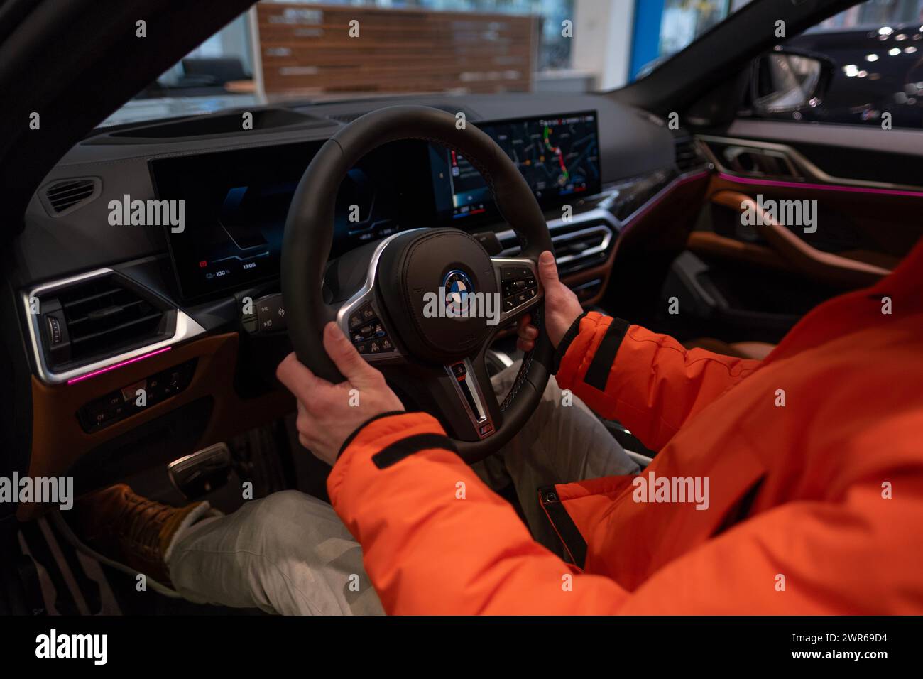 close-up man in car driving BMW i4 five-door electric liftback class D ...