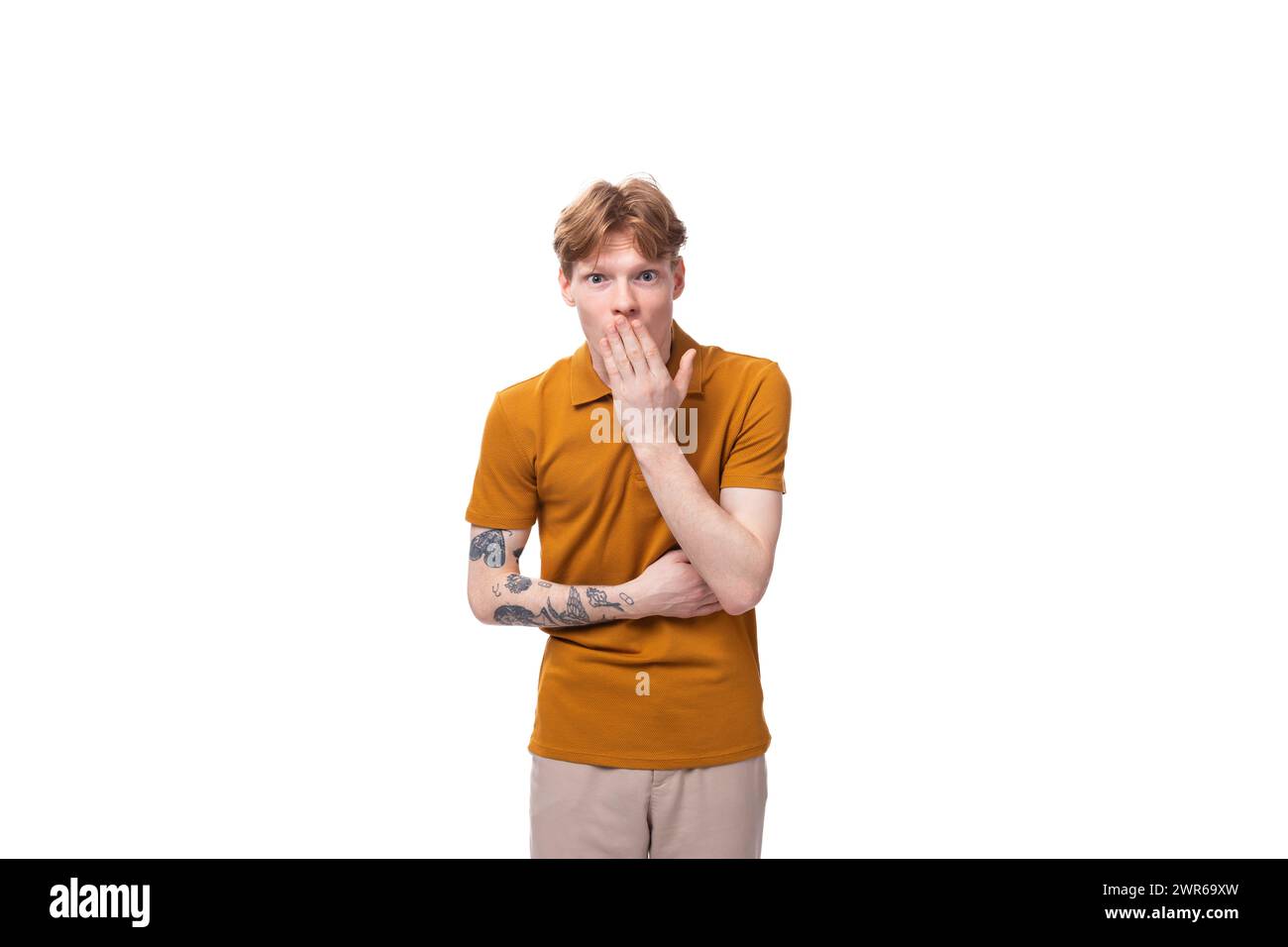 young smart guy with red hair stands thoughtfully on a white background ...