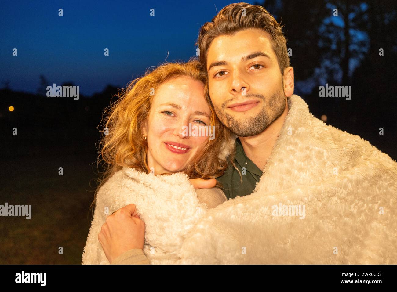 This image exudes warmth and affection, capturing a couple wrapped in a ...