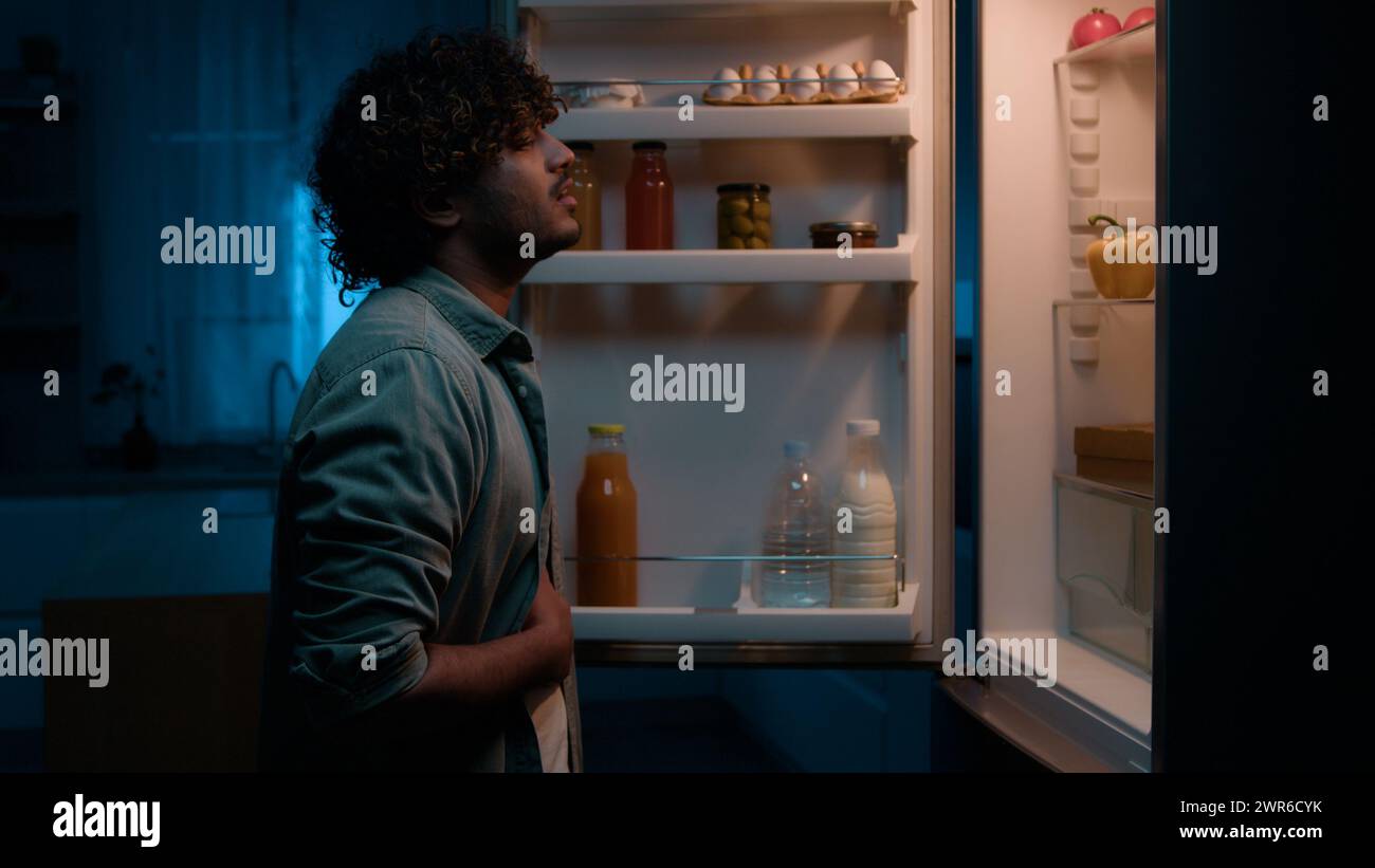 Home kitchen at night dark room hungry Hispanic man Indian male guy ...
