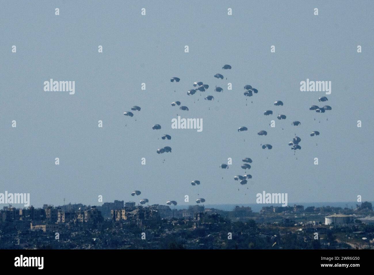 Parachutes drop humanitarian aid into the northern Gaza Strip, as seen ...