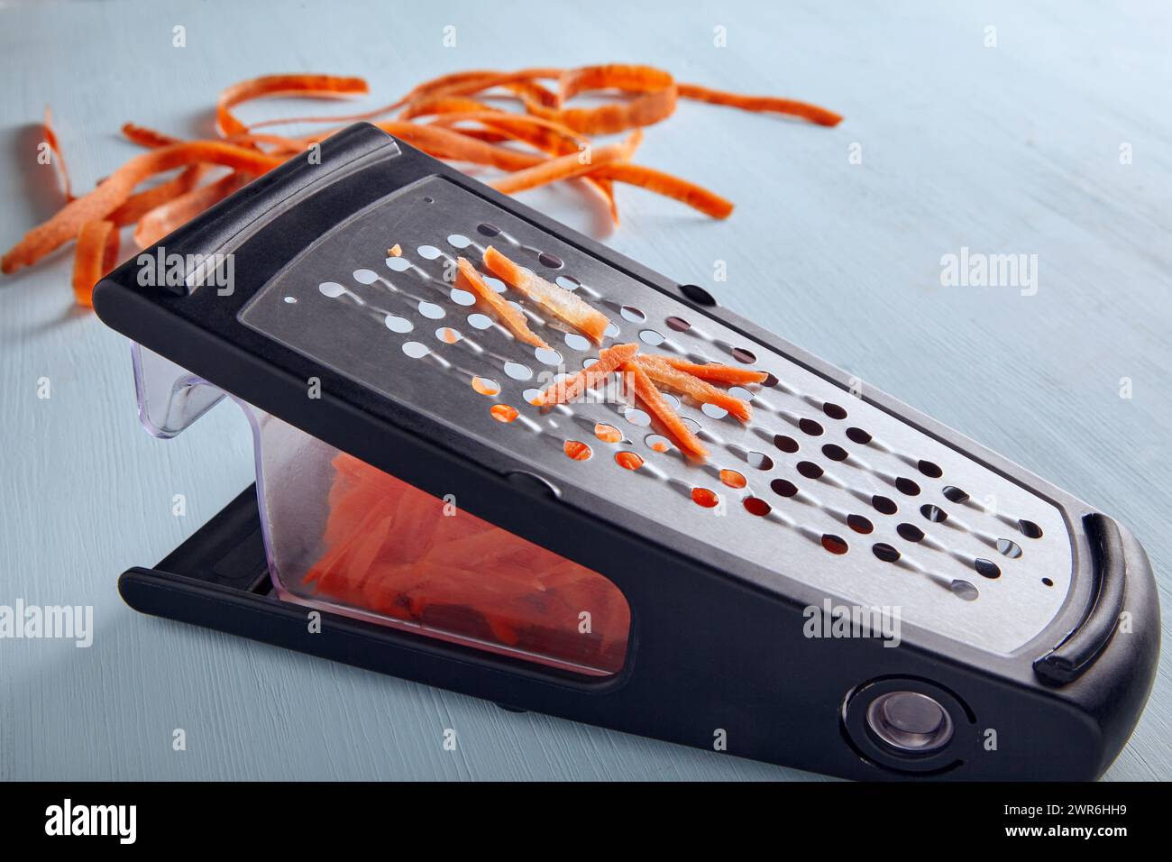 Metal grater and grated shredded carrots on a blue background Stock ...