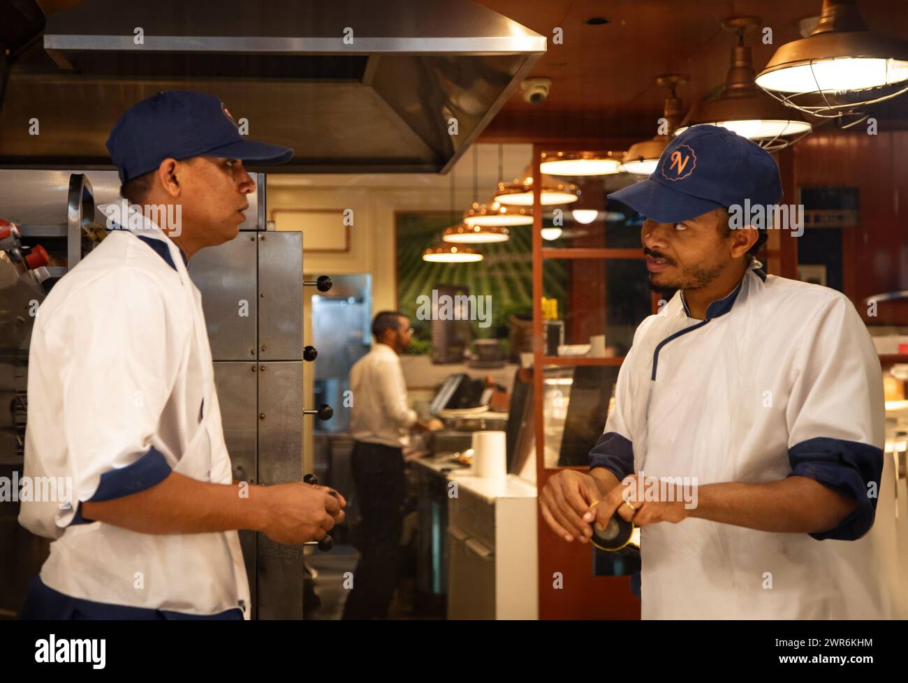In the restaurant's bustling kitchen, two expert chefs meticulously ...