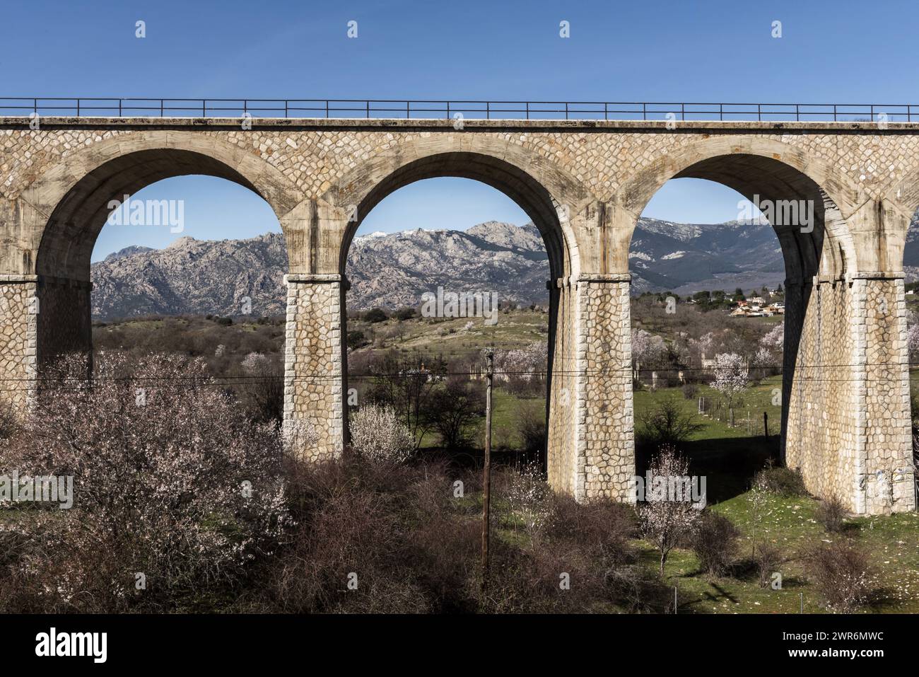 Stone train bridge with views of the Madrid mountains Stock Photo - Alamy