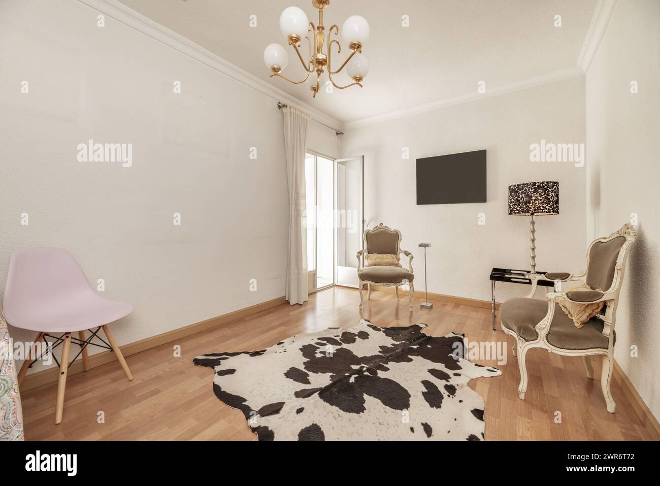a living room with cowhide floor, corner lamp, golden ceiling lamp with ...