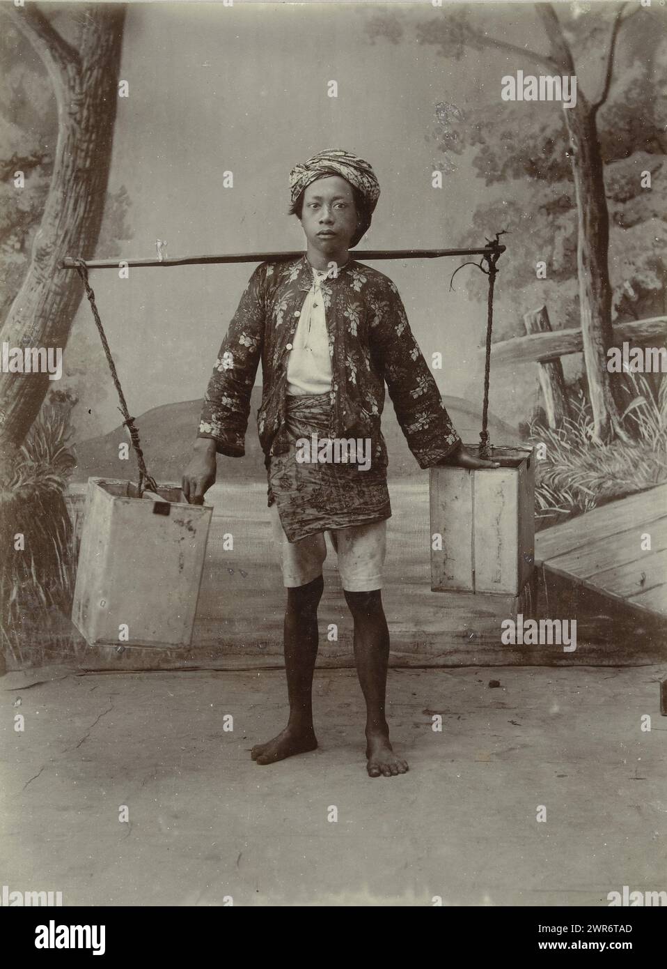 Studio portrait of a young man with a yoke with two cans, Young man ...