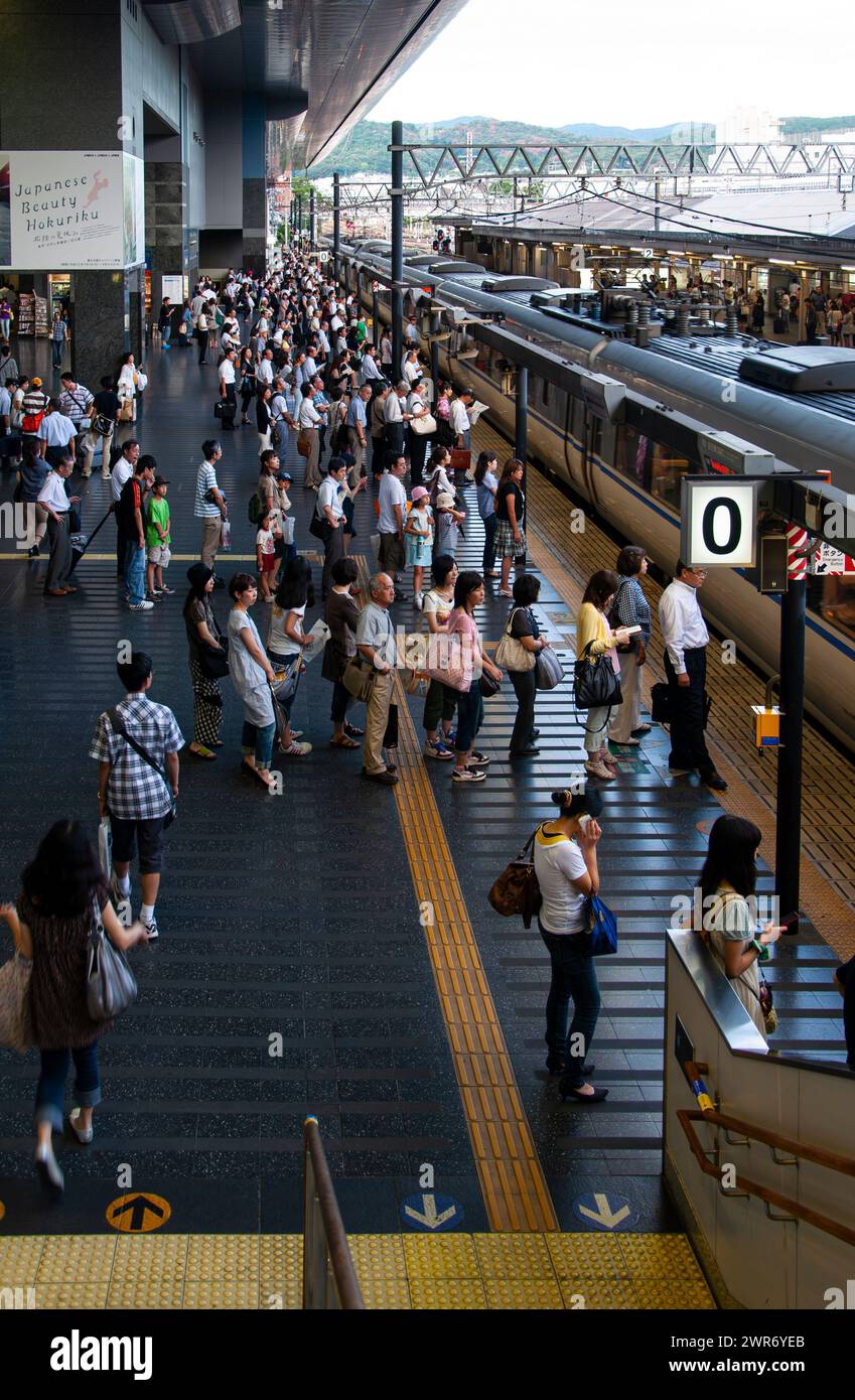 Passengers waiting in line for their train, Kyoto railway station ...