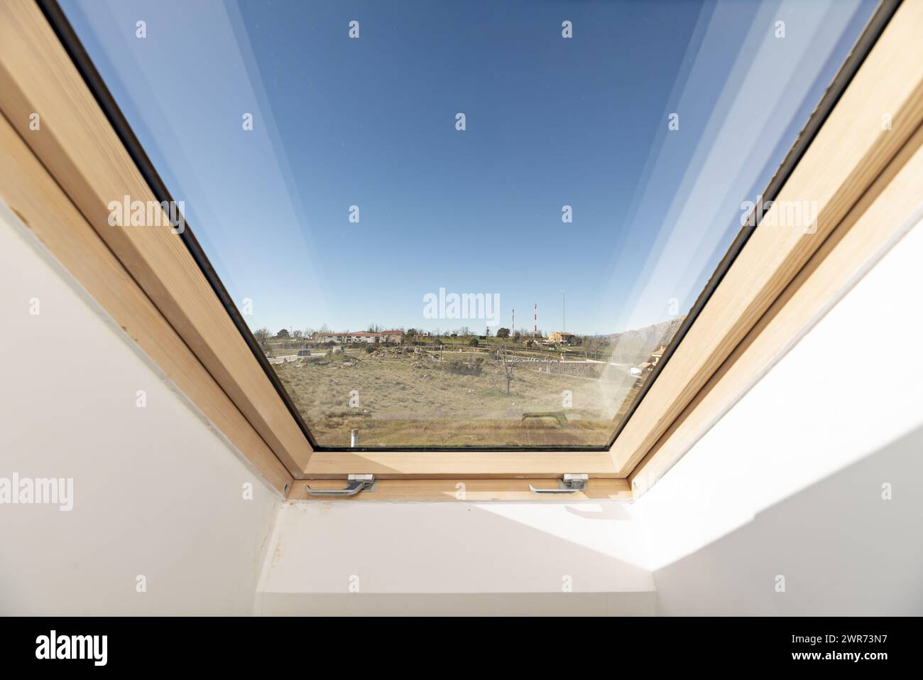 Skylight with wooden structure and metal mesh of an attic room with ...