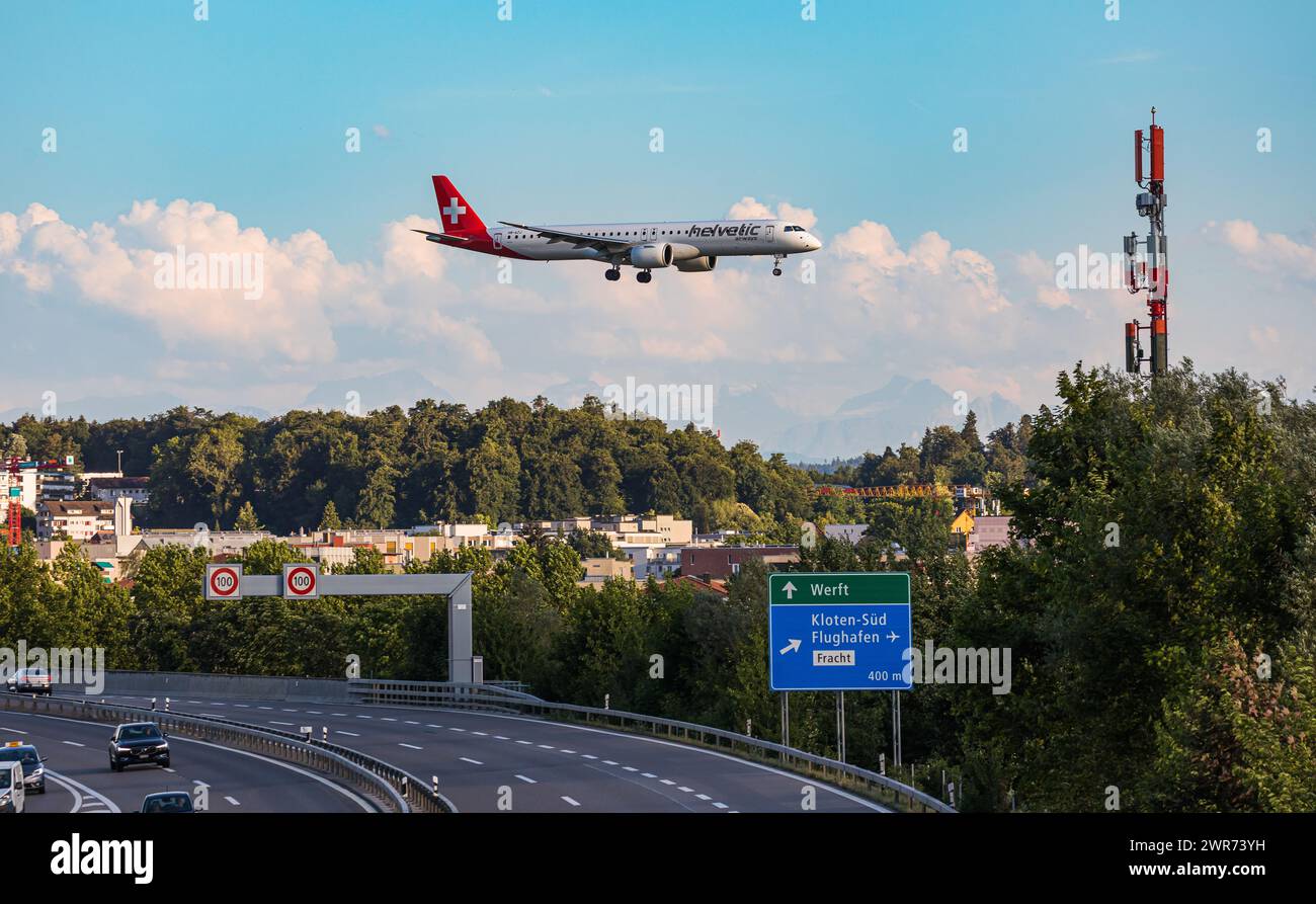 Ein Embraer 190-E2 von Helvetic Airways befindet sich über der Stadt ...