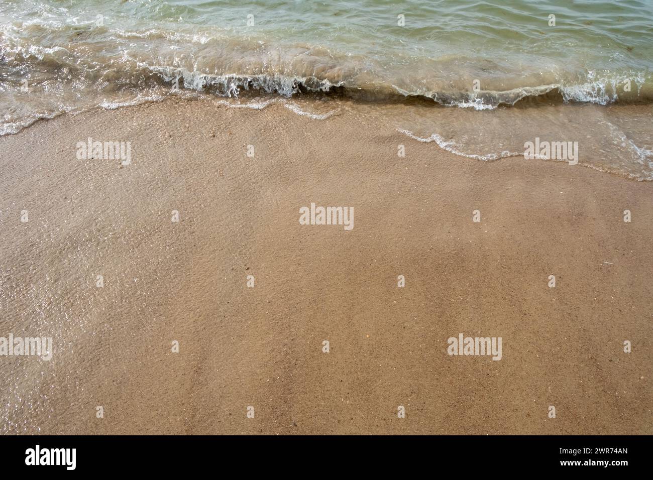 This image captures the simplicity and calmness of gentle waves lapping ...