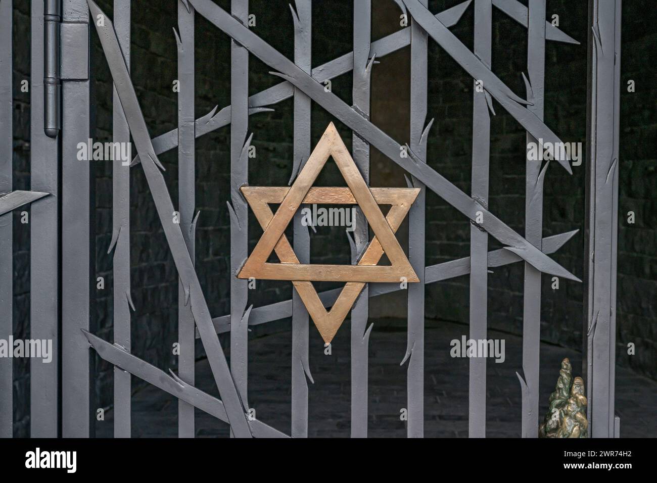A jewish Star of David, made of golden metal on a black metal fence ...