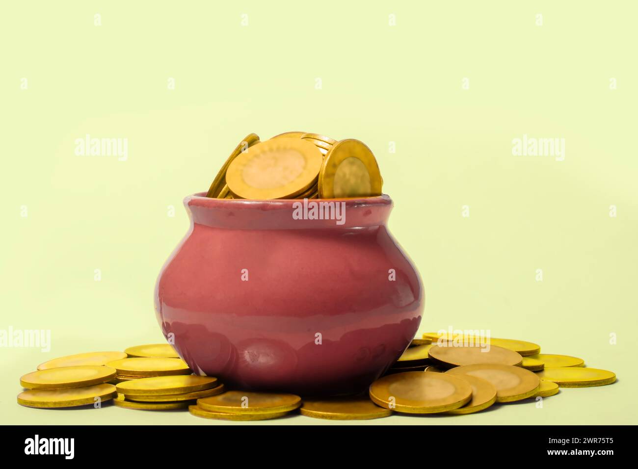 Porcelain pot with gold coins on green background with copy space ...