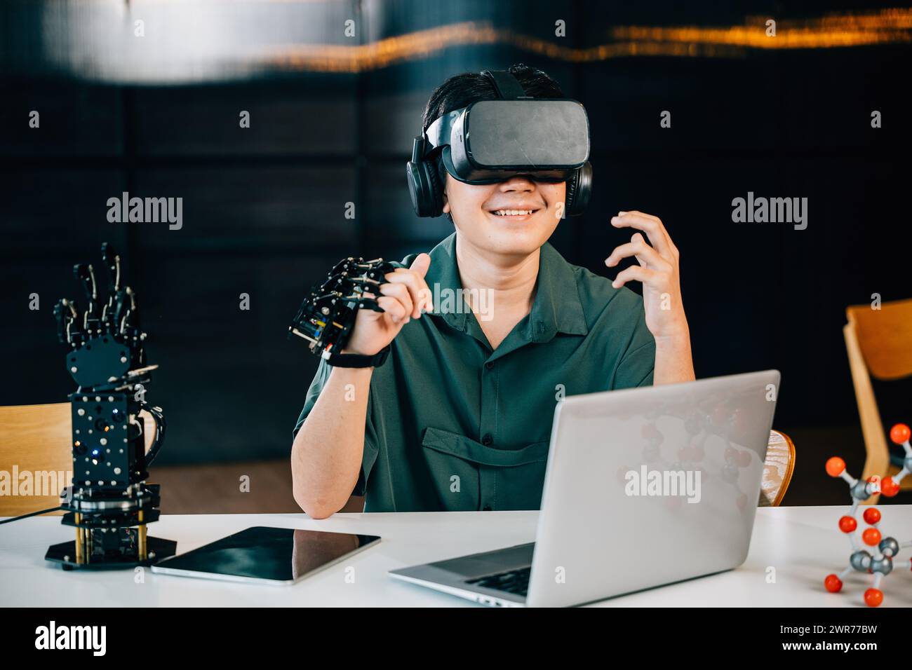 Asian teenager using VR glasses controls a robot arm project in a ...