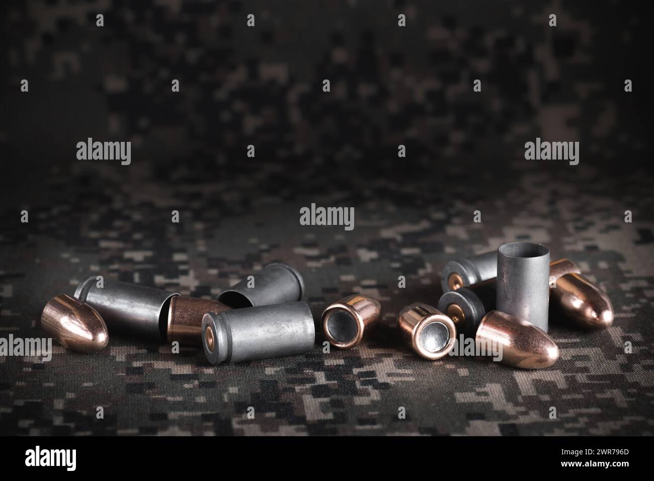 Demounted handgun bullet shell sets in bulk on camouflage military ...