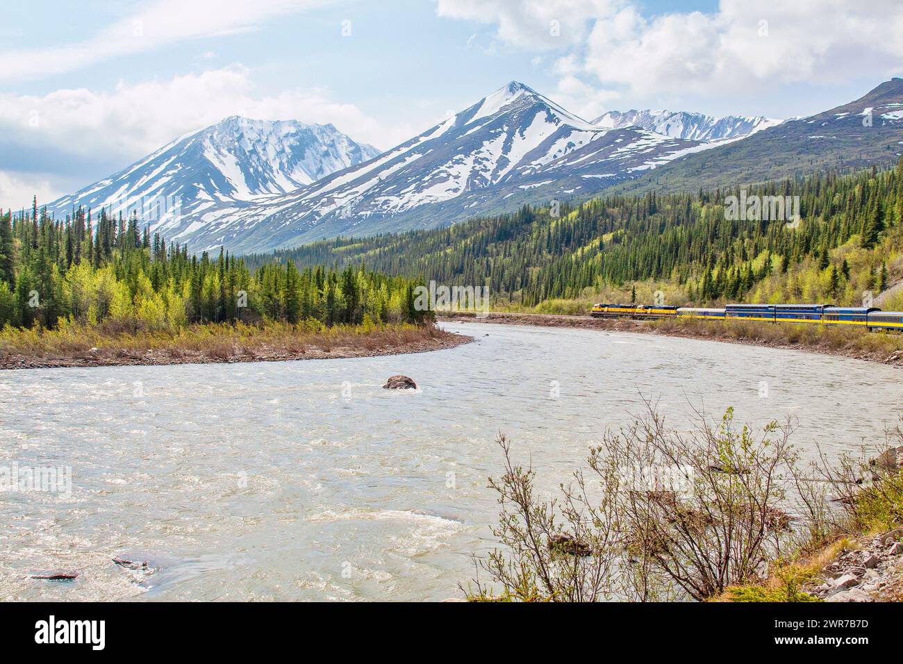 Train travelling around river in the remote wilderness area of Alaska ...