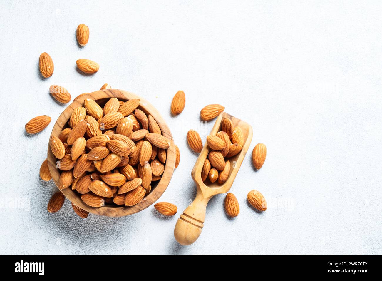 Almond nuts in wooden bowl at white background Stock Photo - Alamy