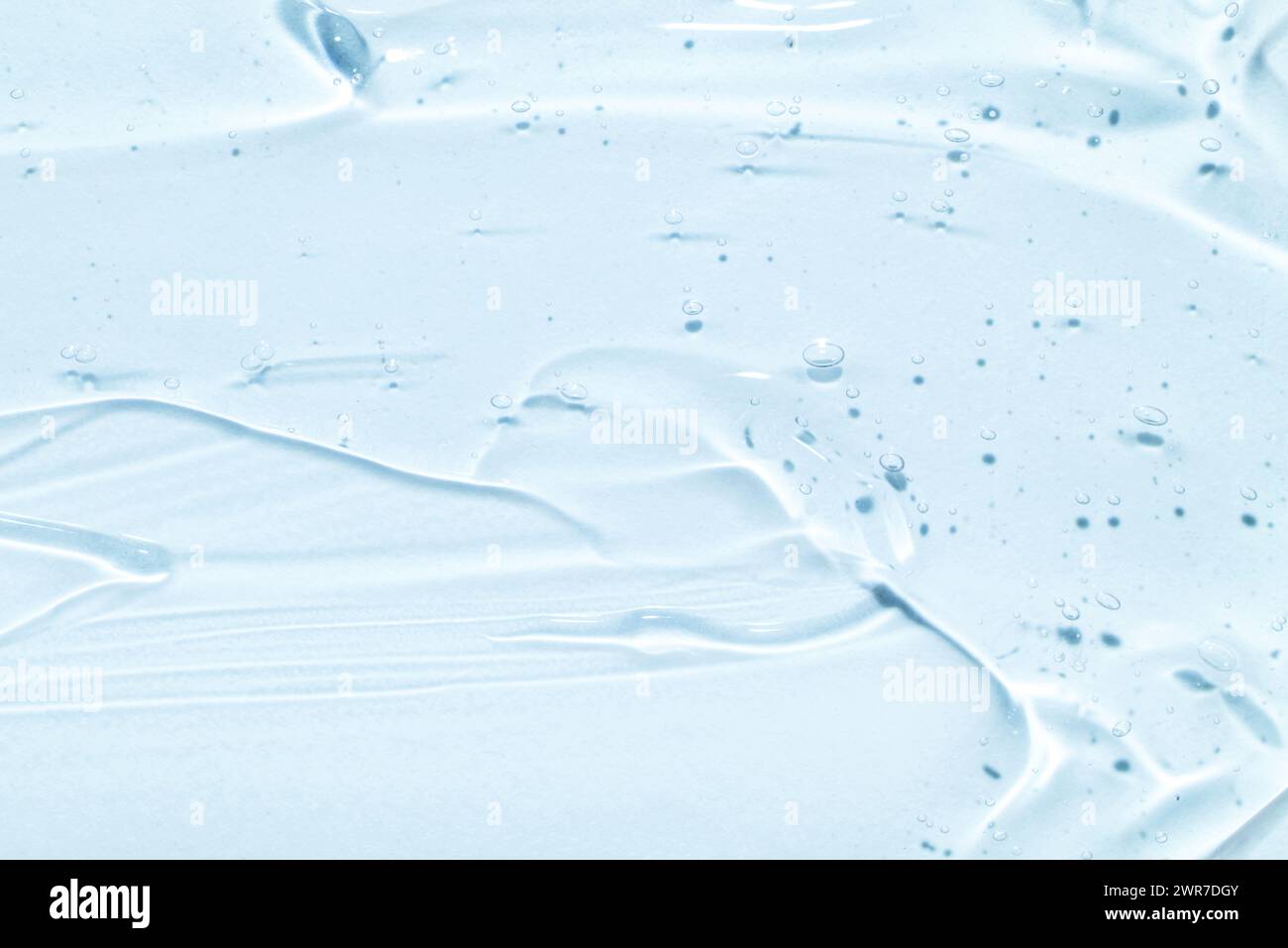 The smear of a transparent gel on a blue background. The texture of the ...