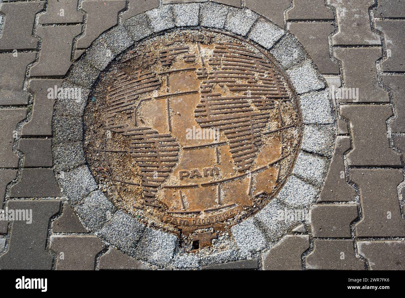 Metal sewage manhole cover, engraved with a world map. Wałbrzych ...