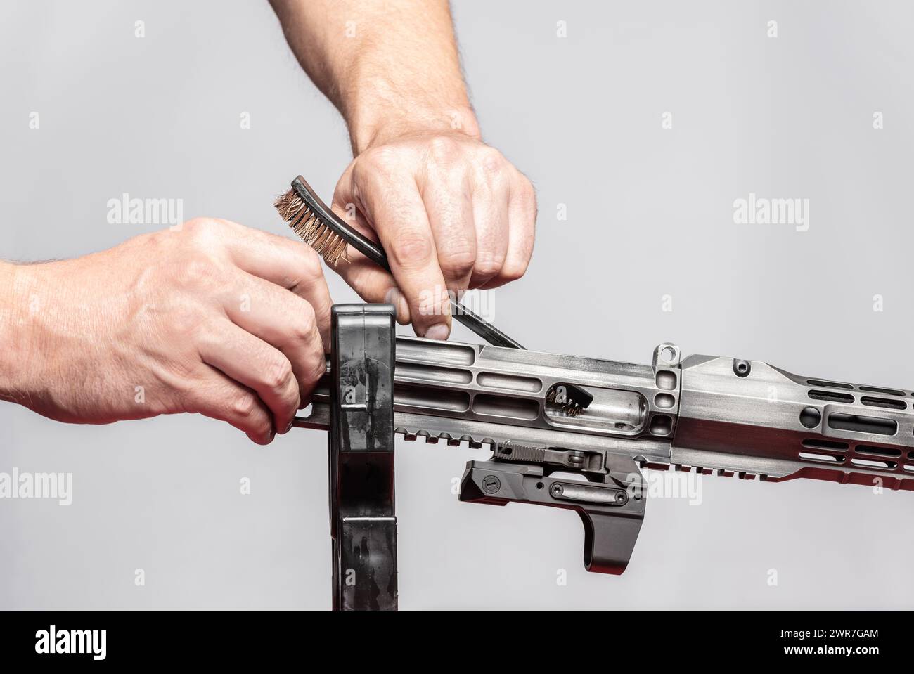 Man`s hands holding rifle parts details and cleaning the gun by metal ...