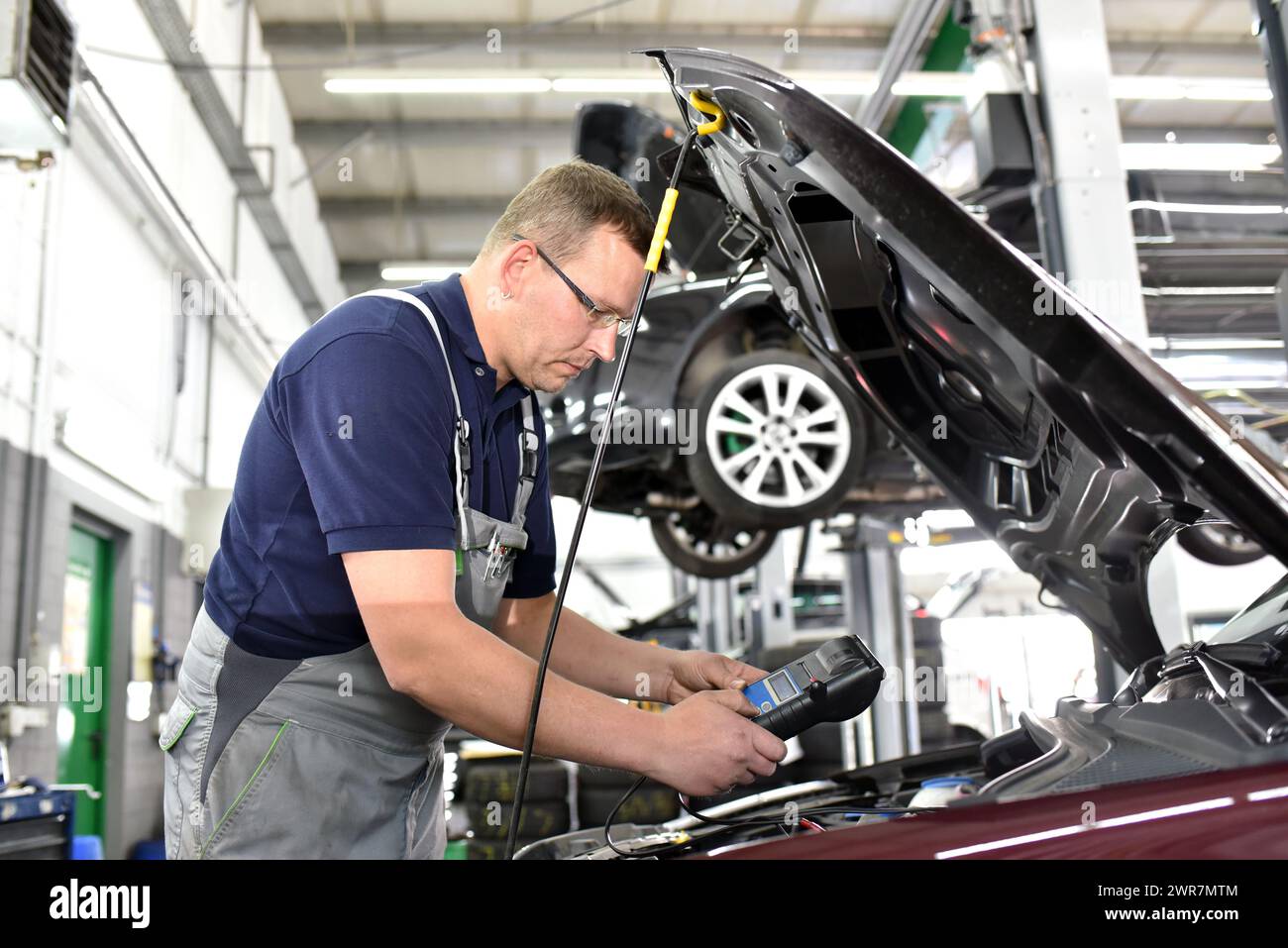 car mechanic in a workshop - engine repair and diagnosis on a vehicle ...